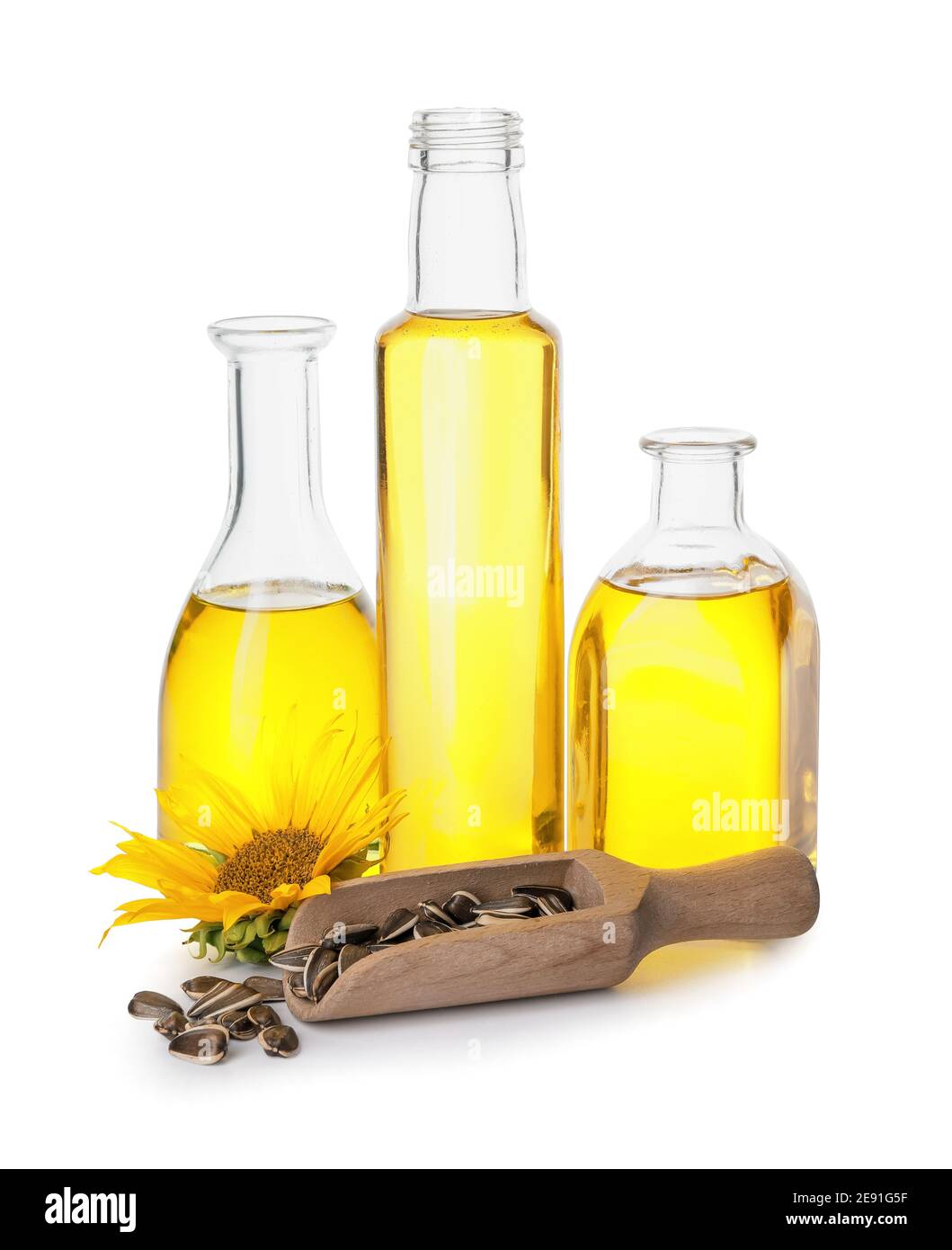Bottles of oil, scoop with seeds and sunflower on white background ...