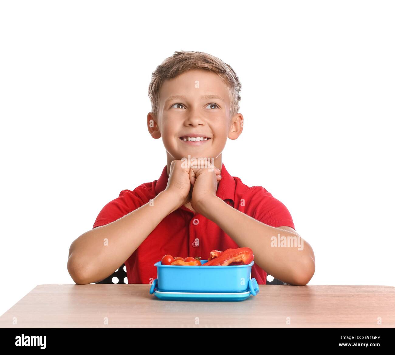 Schoolboy with lunchbox on desk against white background Stock Photo ...