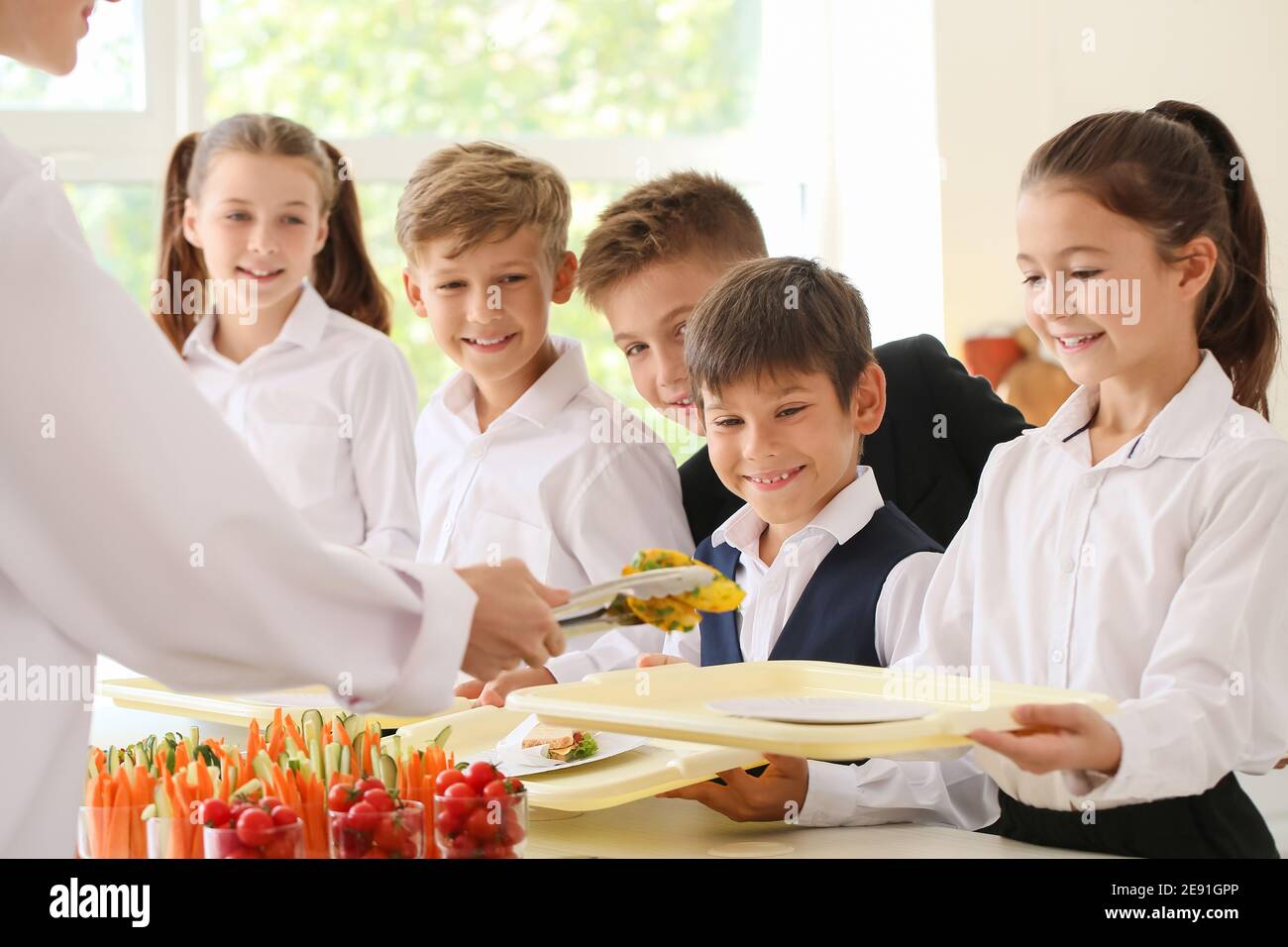 Pupils receiving lunch in school canteen Stock Photo - Alamy