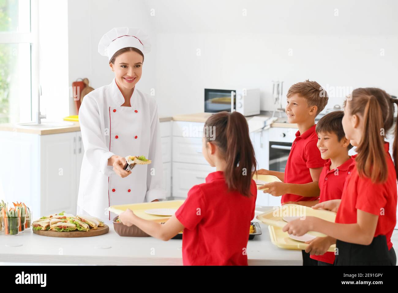 Pupils receiving lunch in school canteen Stock Photo - Alamy