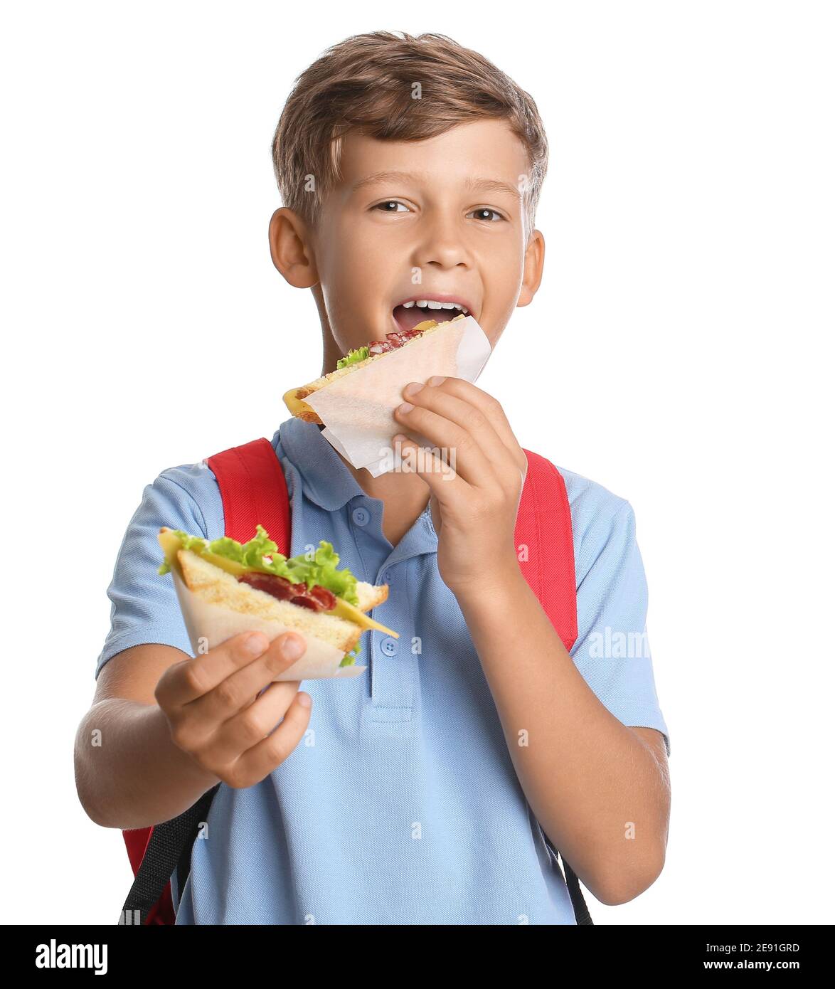Schoolboy eating sandwich on white background Stock Photo - Alamy