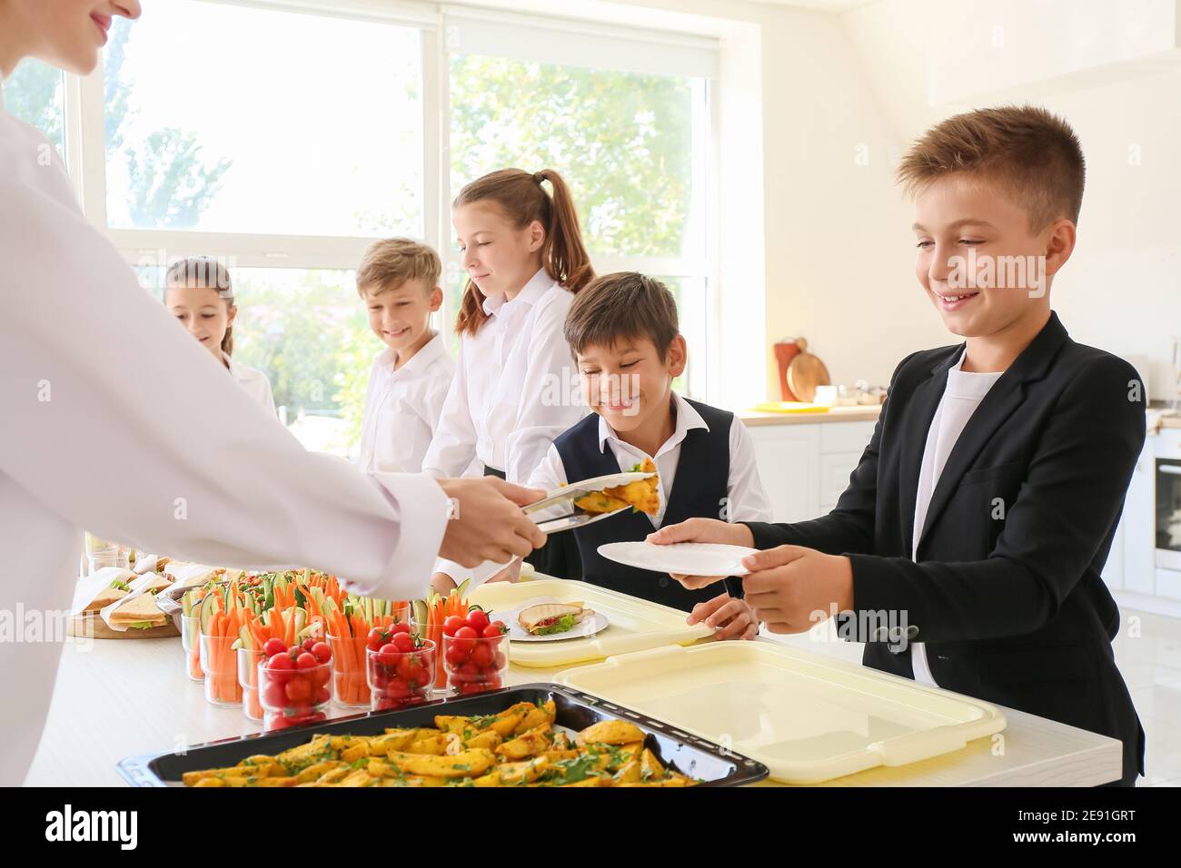 Pupils receiving lunch in school canteen Stock Photo - Alamy