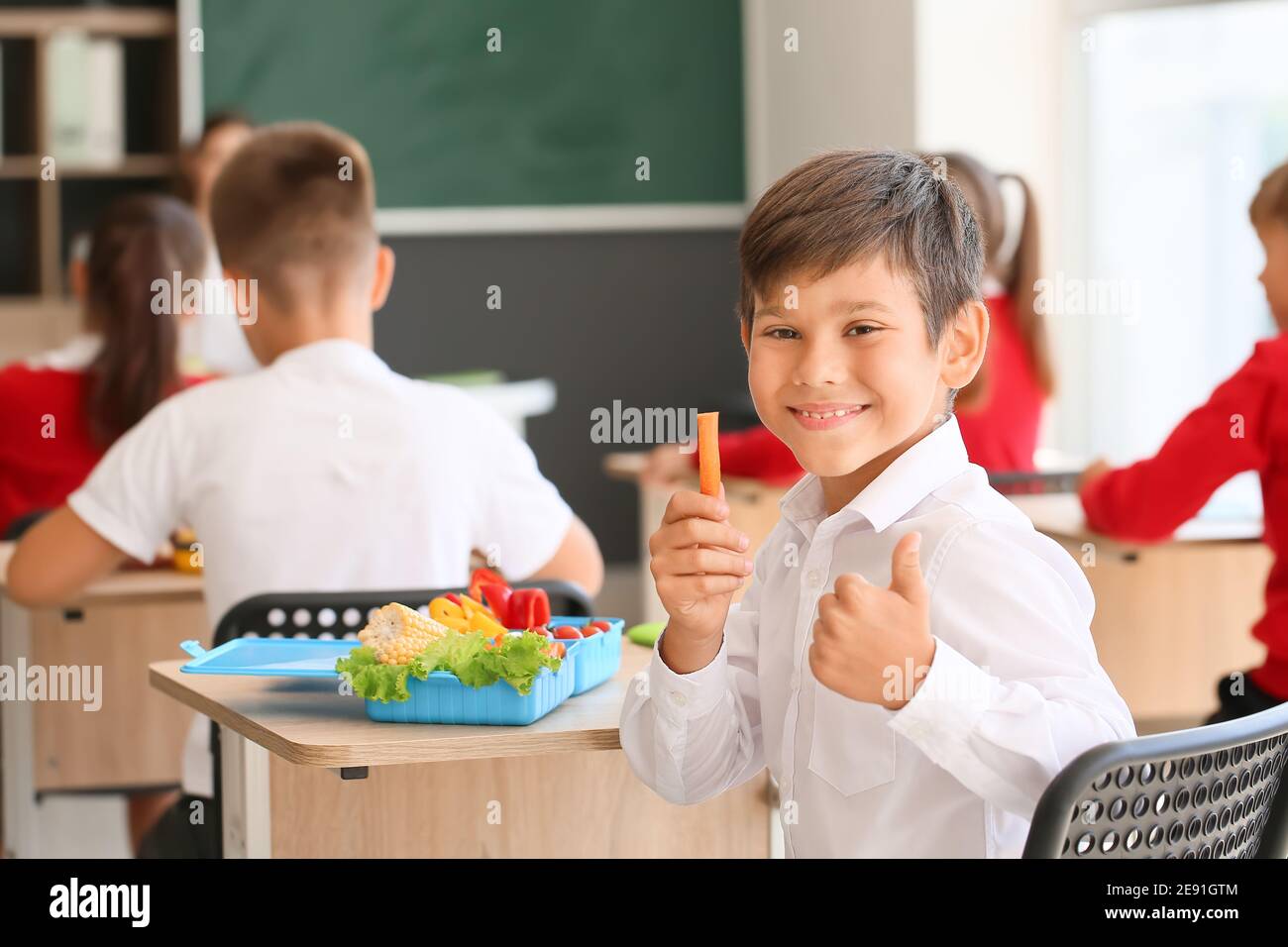 Schoolboy having healthy lunch in classroom Stock Photo - Alamy