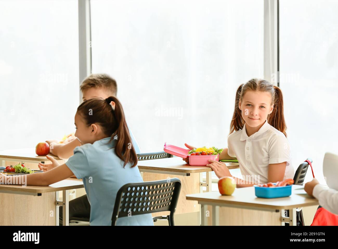 Pupils having healthy lunch in classroom Stock Photo - Alamy