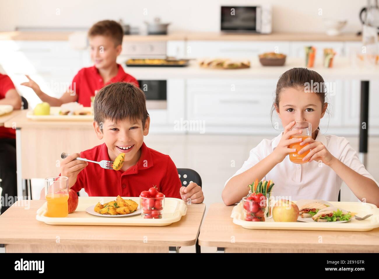 Pupils having healthy lunch in classroom Stock Photo - Alamy