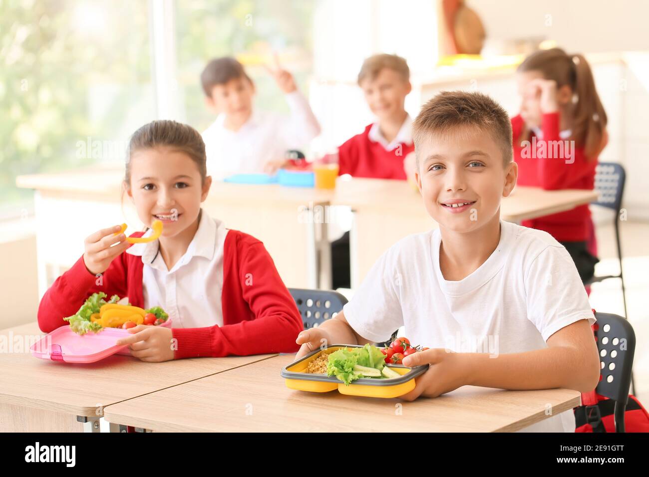 Pupils having healthy lunch in classroom Stock Photo - Alamy