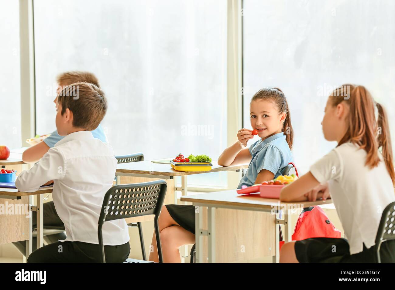 Pupils having healthy lunch in classroom Stock Photo - Alamy