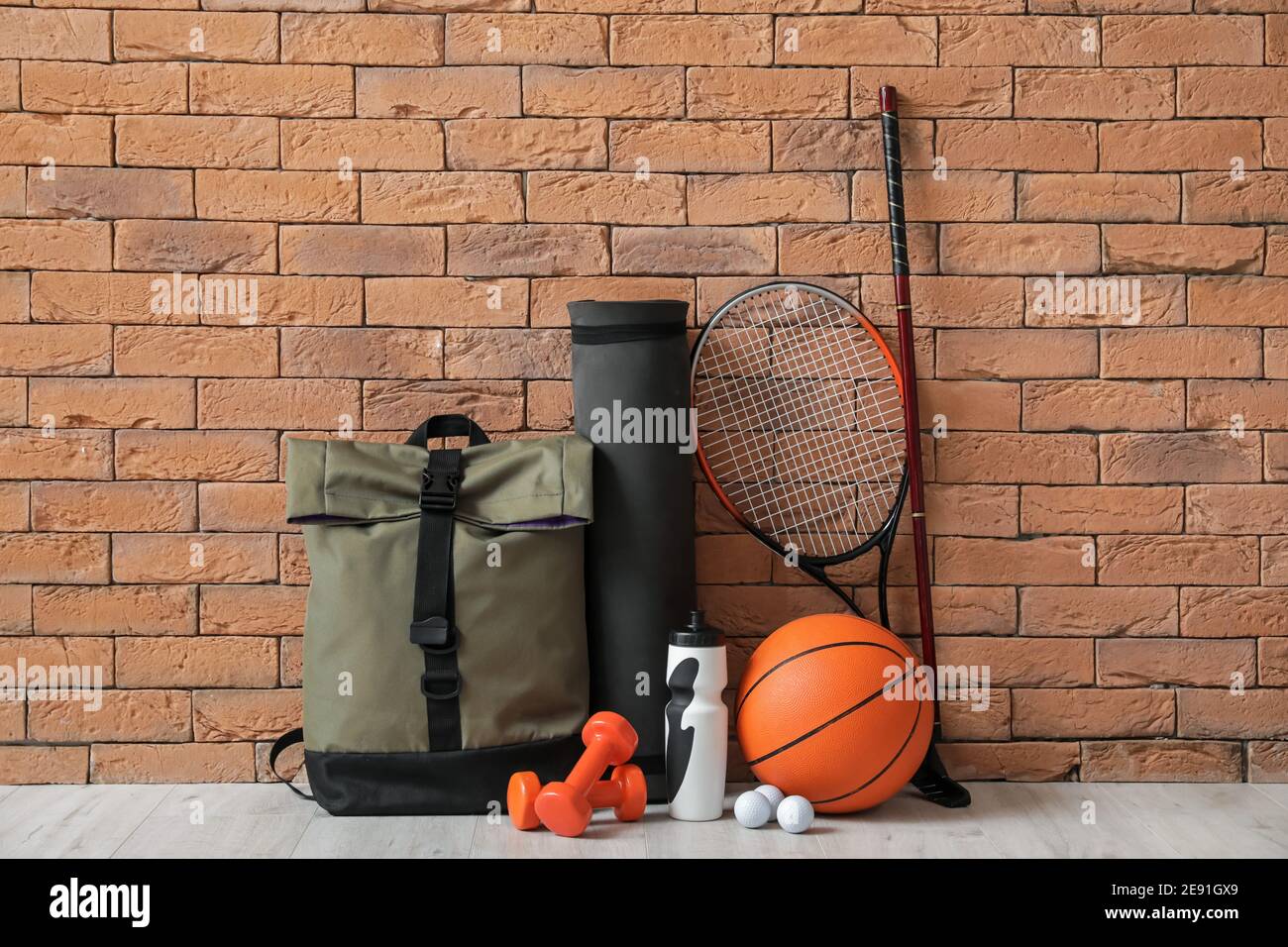 Set of sports equipment on floor near brick wall Stock Photo - Alamy
