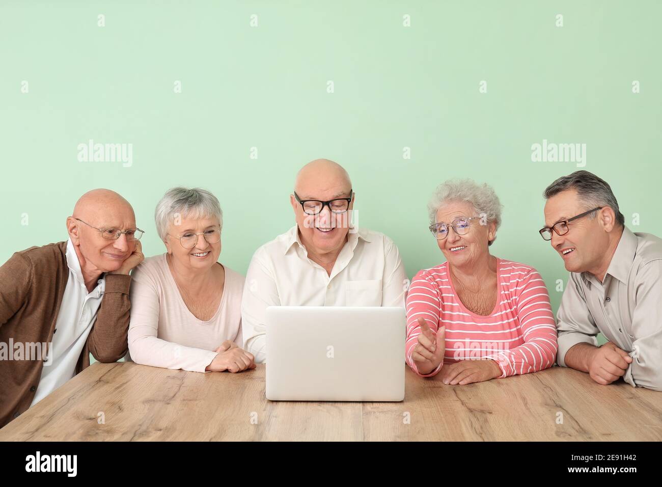 Senior people video chatting at table in room Stock Photo - Alamy
