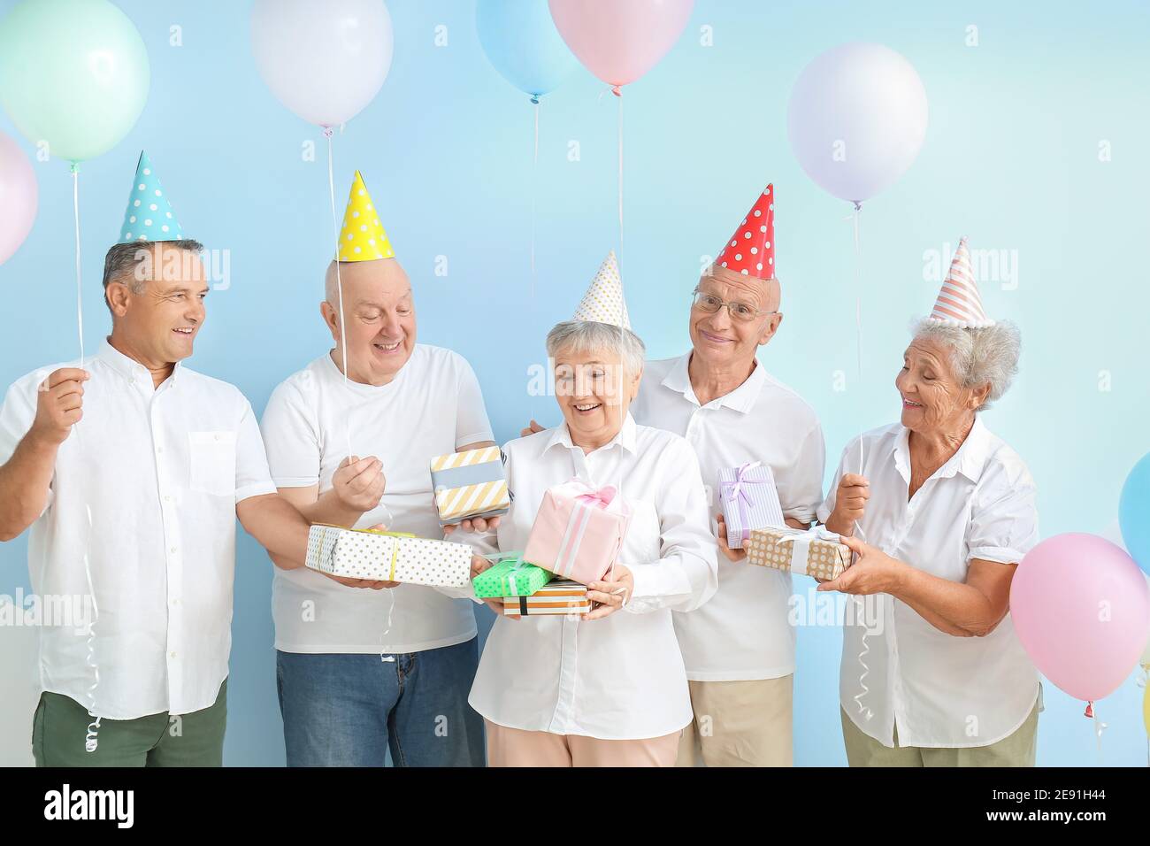 Senior people celebrating Birthday near color wall Stock Photo - Alamy