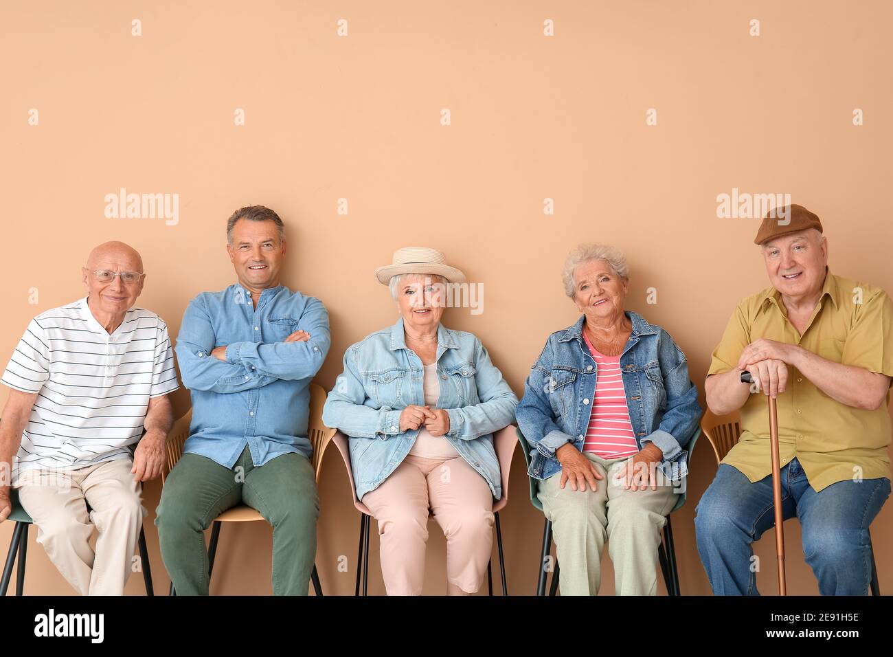 Senior people sitting on chairs in room Stock Photo - Alamy