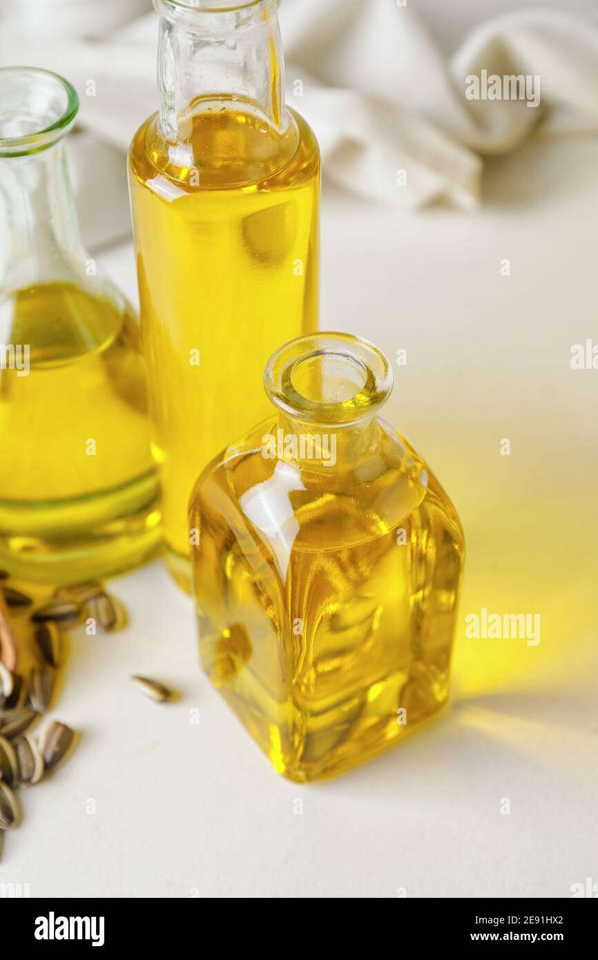 Bottles of oil and seeds on light background Stock Photo - Alamy