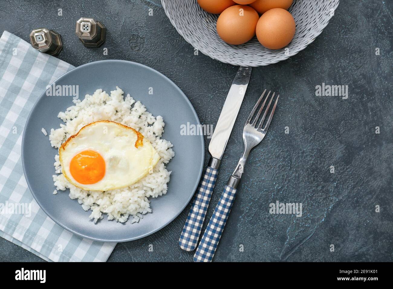 Plate with tasty egg and rice on dark background Stock Photo - Alamy