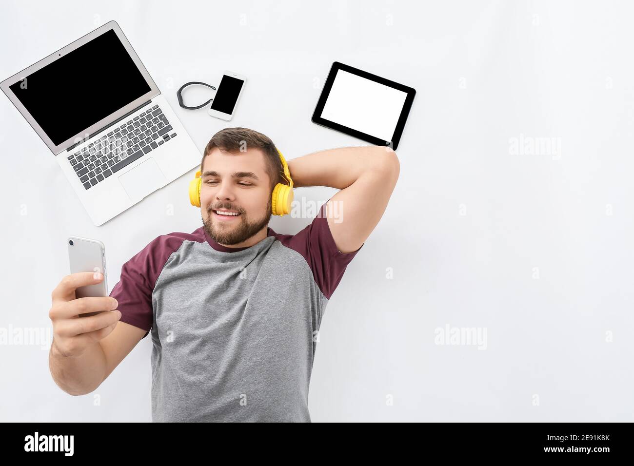 Young man with different gadgets on white background Stock Photo - Alamy