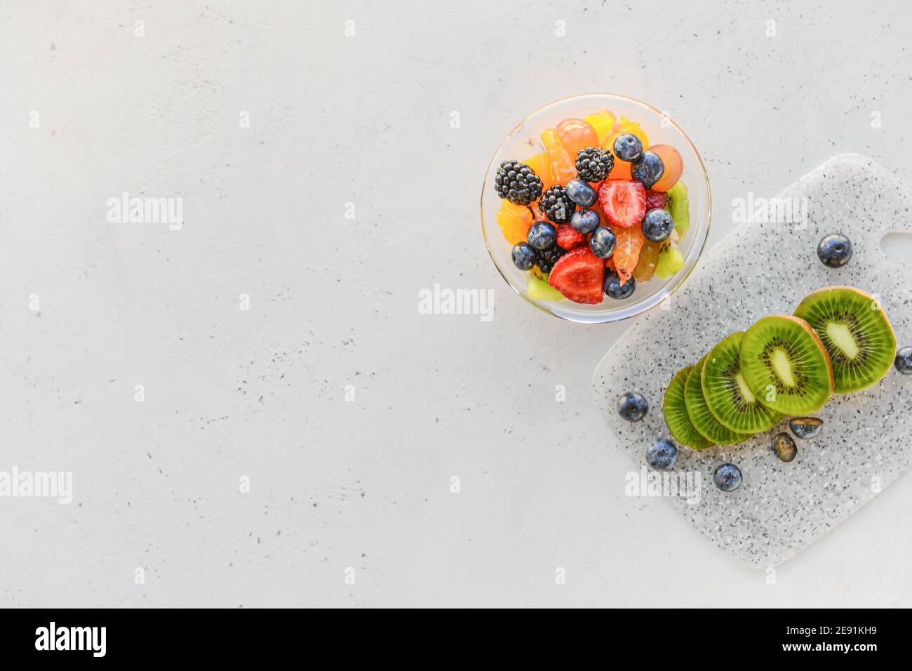 Bowl with fruit salad on light background Stock Photo - Alamy