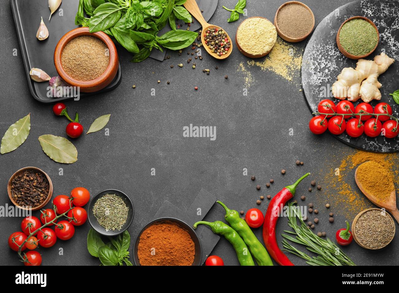 Frame made of different spices, herbs and vegetables on dark background ...