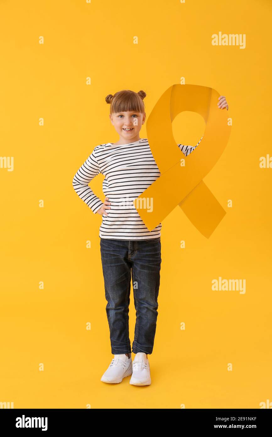 Little girl with golden ribbon on color background. Childhood cancer ...