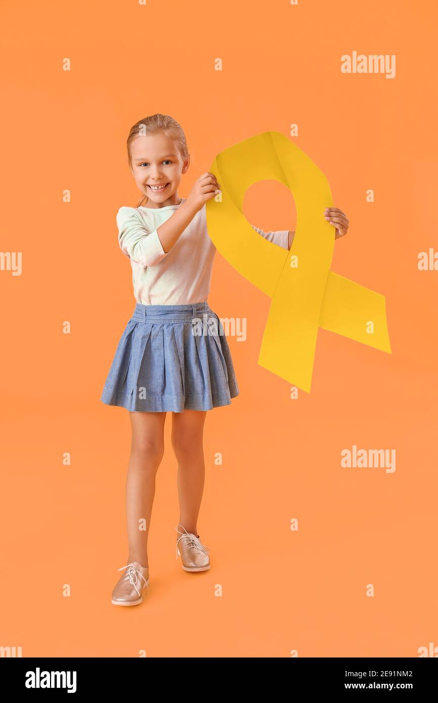 Little girl with golden ribbon on color background. Childhood cancer ...
