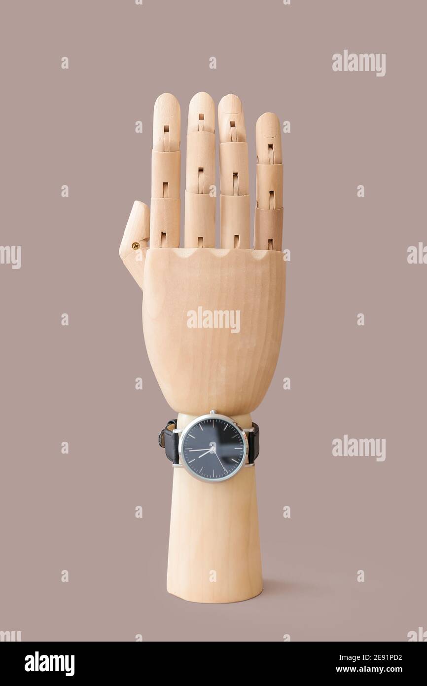 Wooden hand with watch on grey background Stock Photo - Alamy