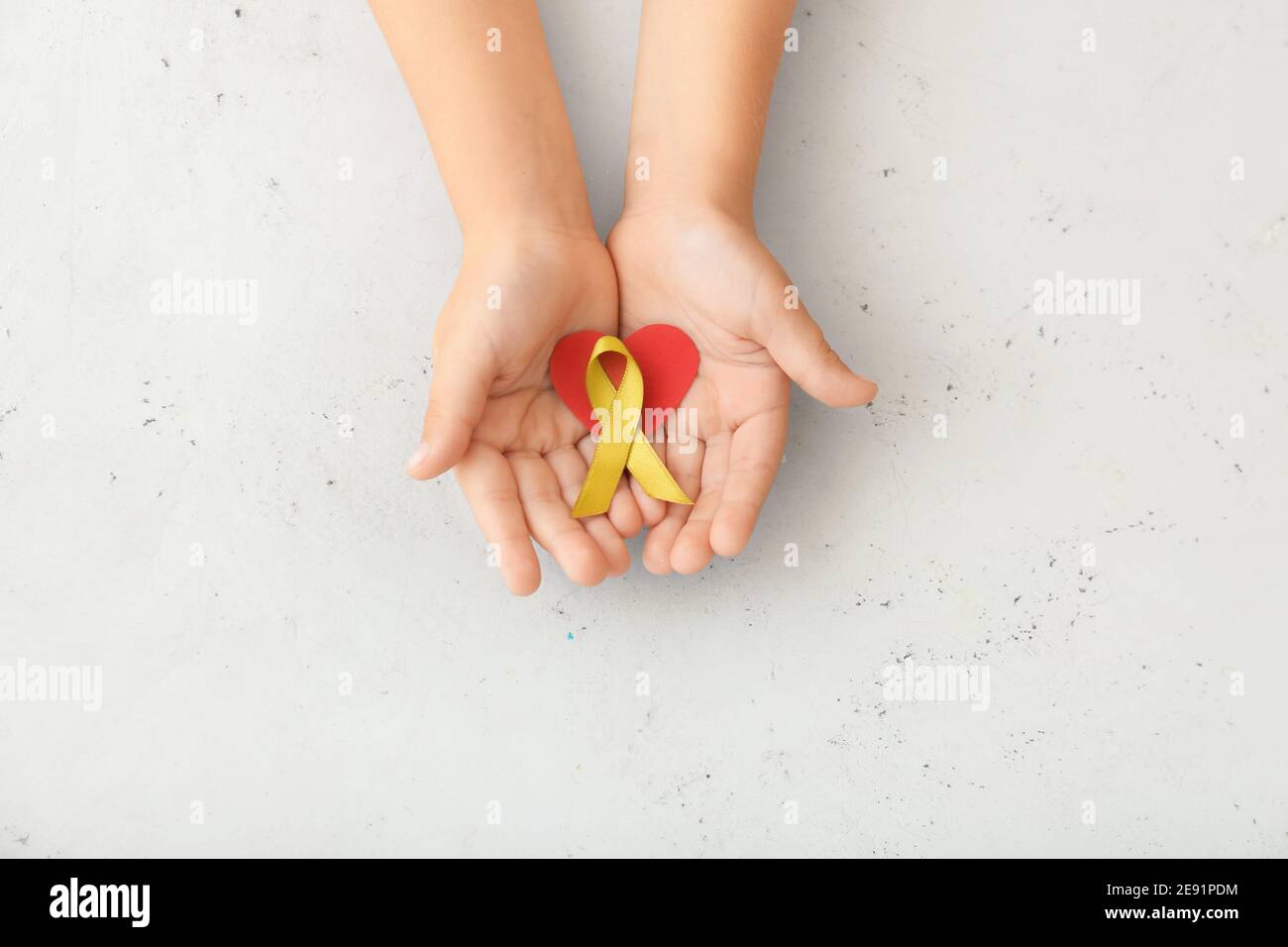 Hands with golden ribbon and red heart on white background. Childhood ...