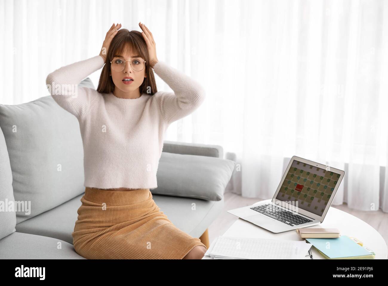 Stressed young woman trying to meet deadline at home Stock Photo - Alamy