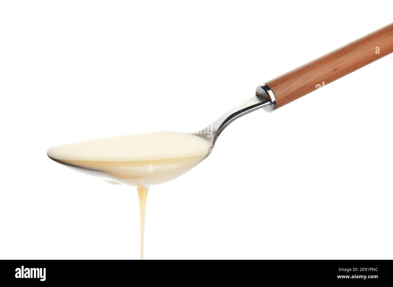 Spoon with sweet condensed milk on white background Stock Photo - Alamy