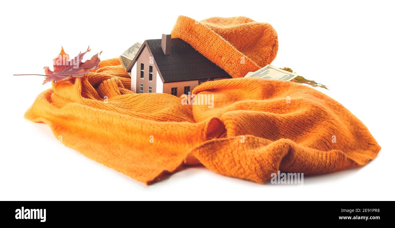 Figure of house, money, autumn leaves and warm clothes on white ...