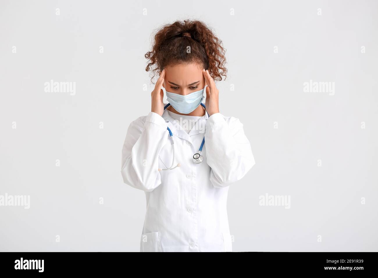 Portrait of stressed female doctor on light background Stock Photo - Alamy