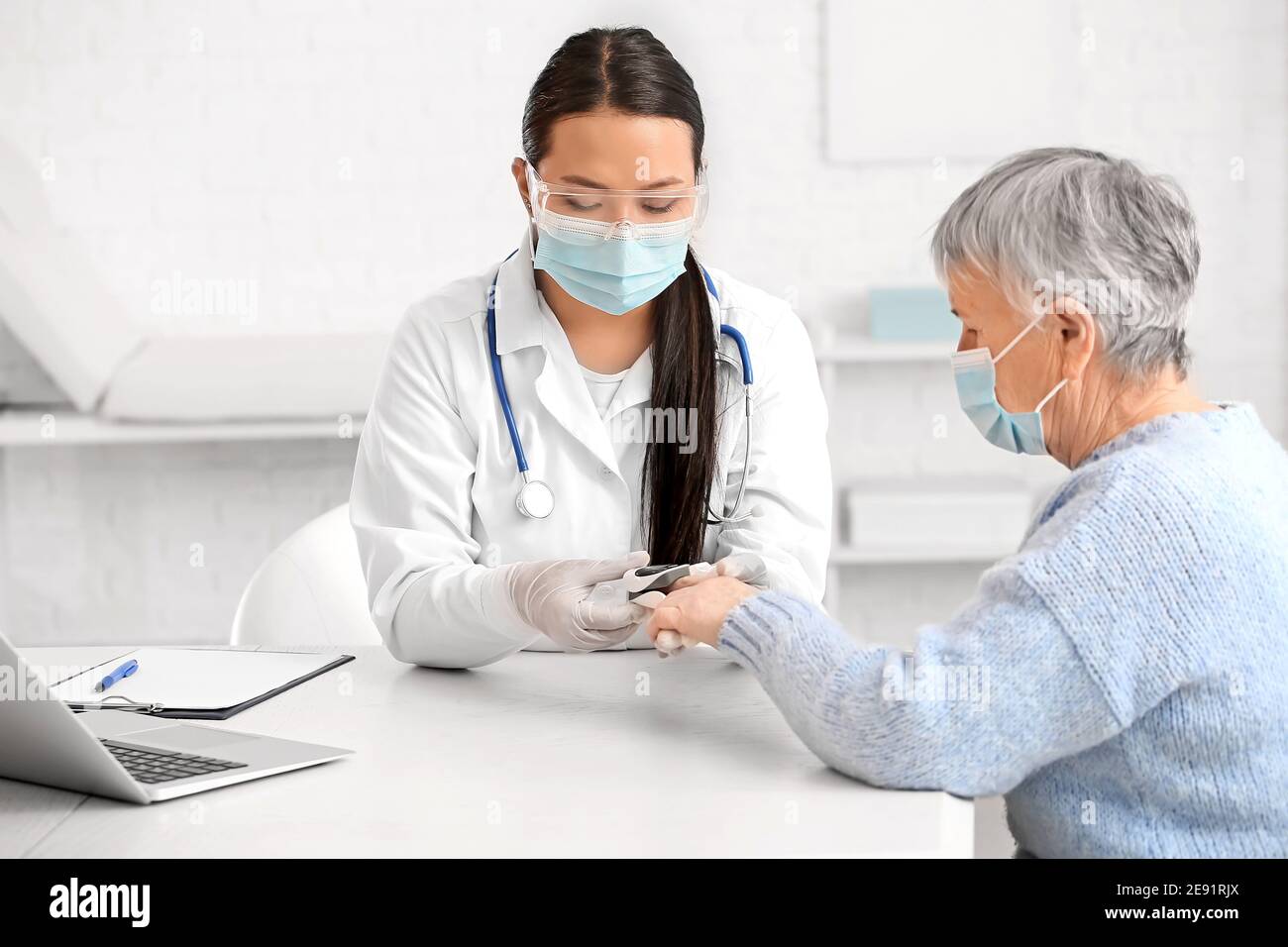 Doctor measuring oxygen saturation level of patient blood in clinic ...