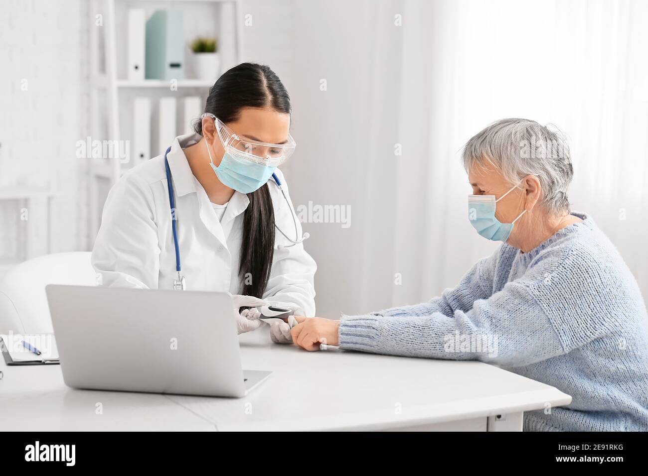 Doctor measuring oxygen saturation level of patient blood in clinic ...