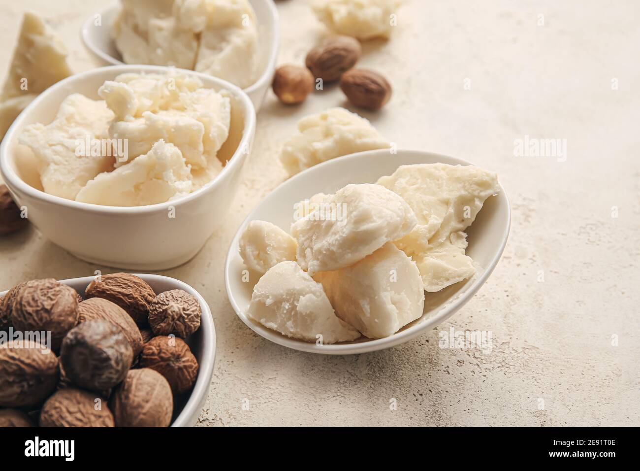 Shea butter and nuts on light background Stock Photo - Alamy