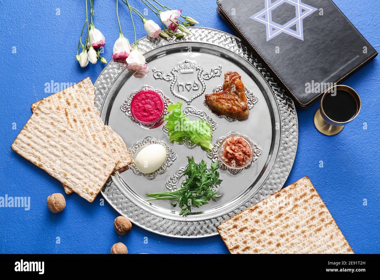 Passover Seder plate with traditional food and Torah on color ...