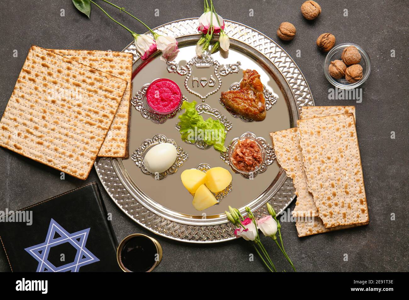 Passover Seder plate with traditional food and Torah on dark background ...