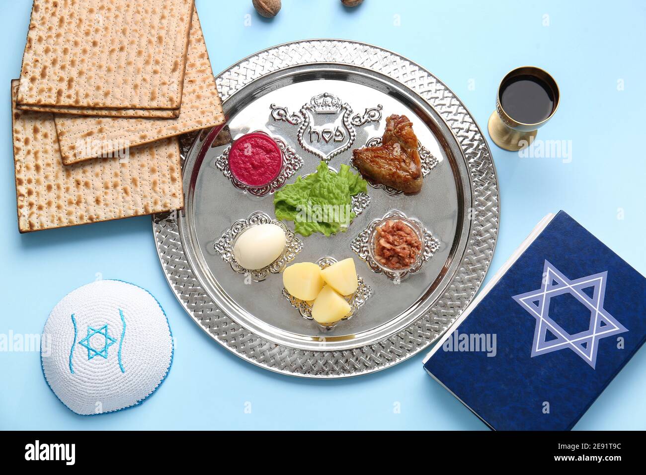 Passover Seder plate with traditional food, Torah and Jewish cap on ...