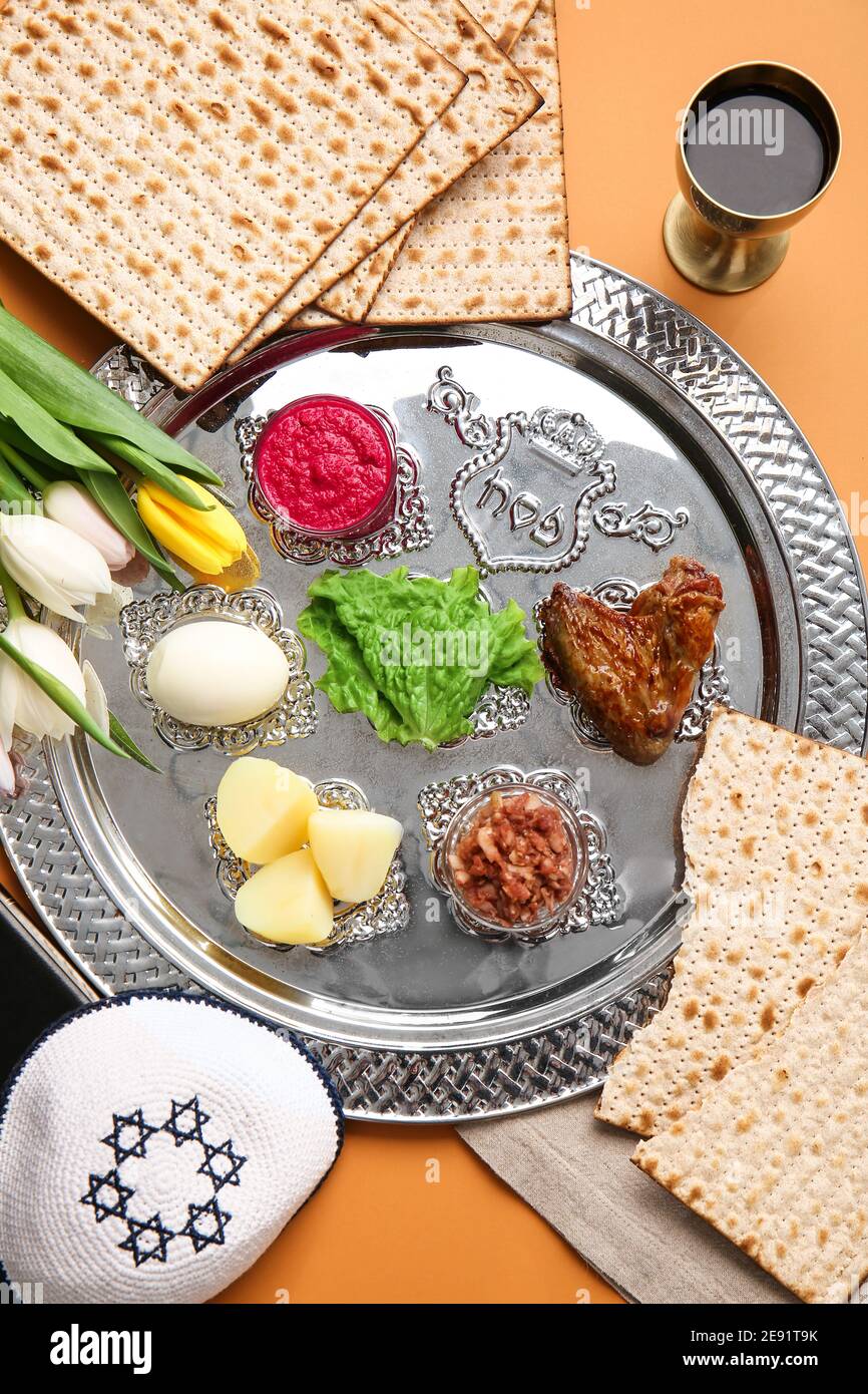Passover Seder plate with traditional food and Jewish cap on color ...