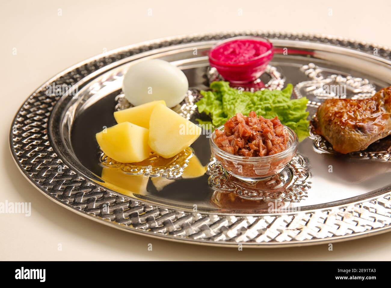 Passover Seder plate with traditional food on light background, closeup ...