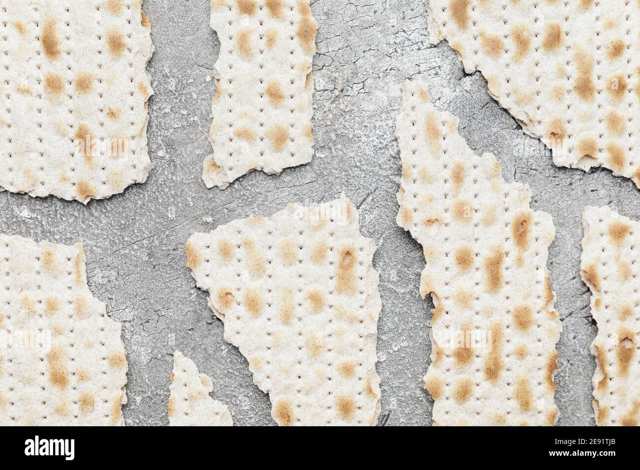 Broken Jewish flatbread matza for Passover on grey background Stock ...