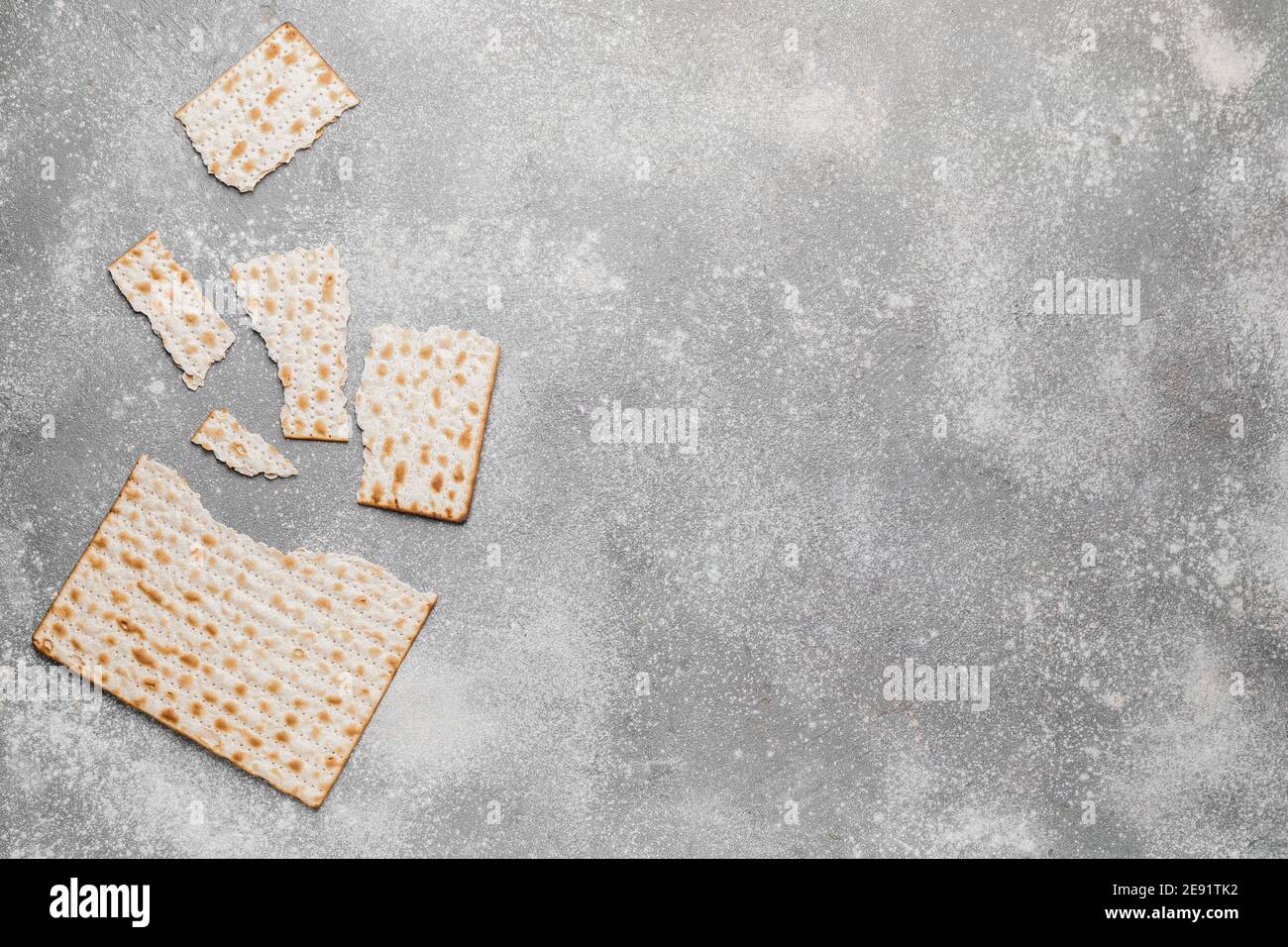 Broken Jewish flatbread matza for Passover on grey background Stock ...