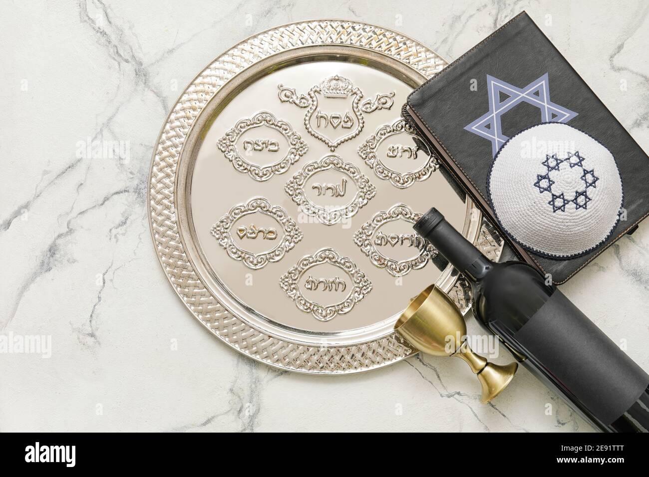 Passover Seder plate with wine, Jewish cap and Torah on white ...