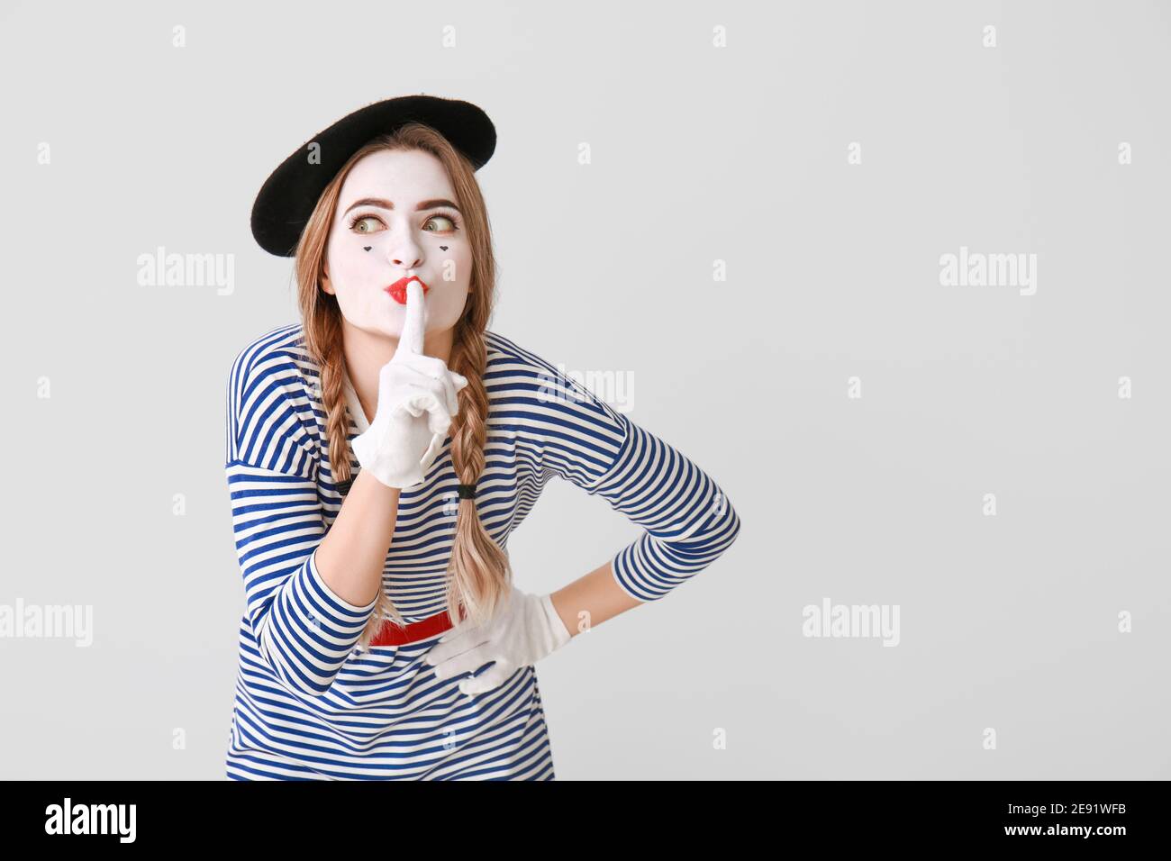 Female pantomimist showing silence gesture on grey background Stock ...
