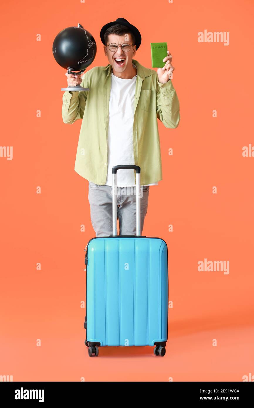 Stressed male tourist with globe and luggage on color background Stock ...