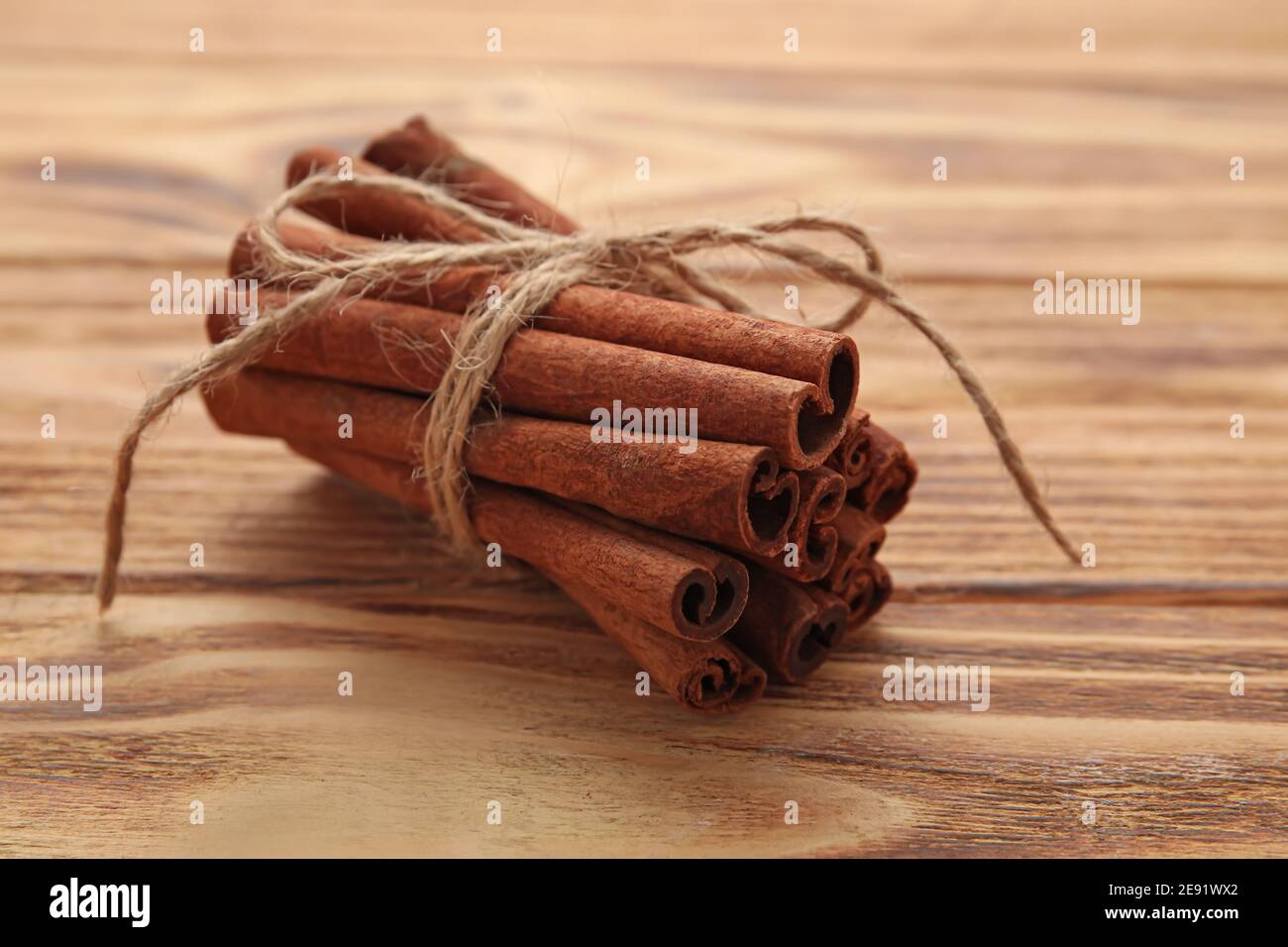 Cinnamon sticks on wooden background Stock Photo - Alamy