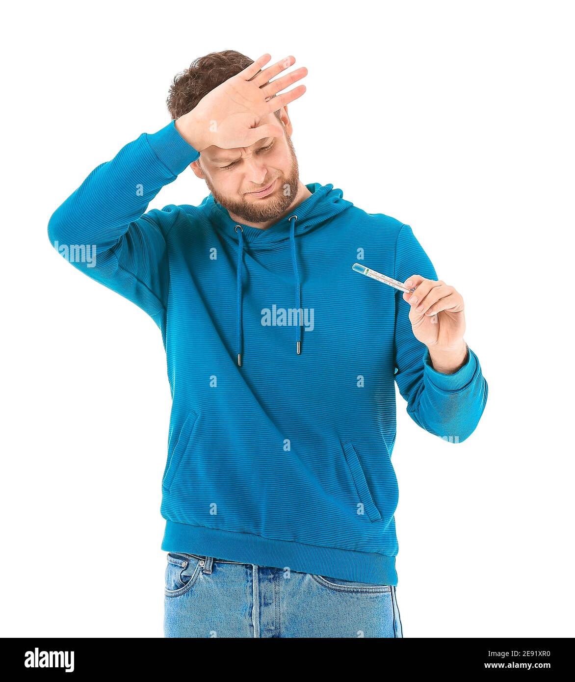 Sick young man measuring temperature on white background Stock Photo ...