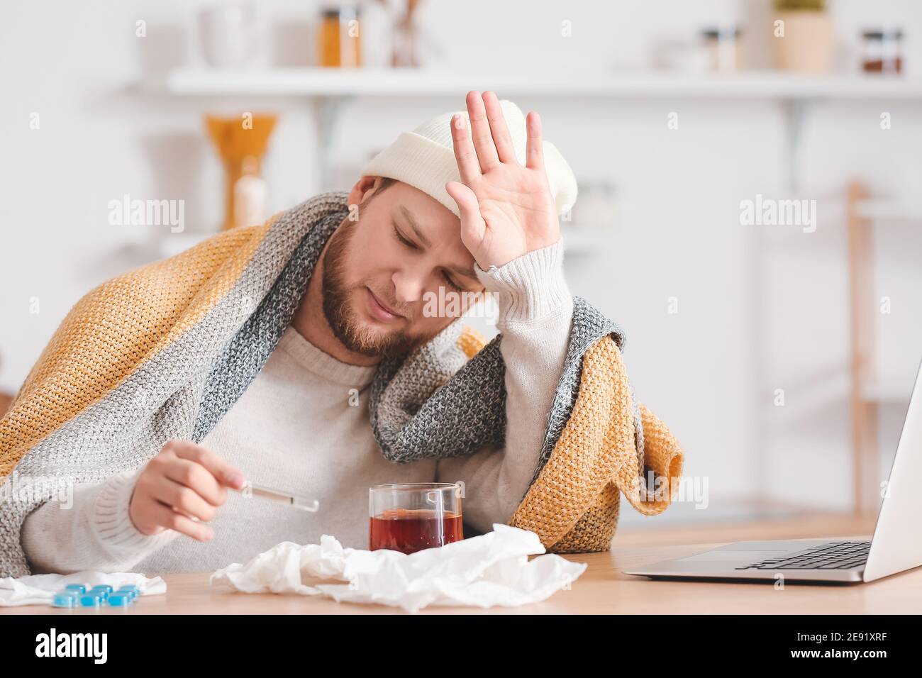Sick young man measuring temperature at home Stock Photo - Alamy