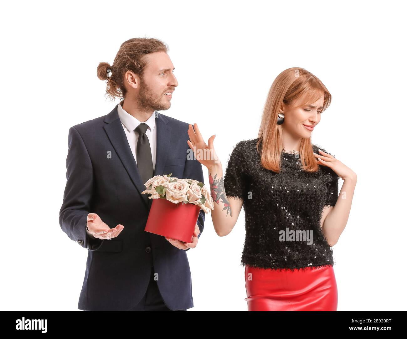 Young man greeting his displeased girlfriend on Valentine's Day against ...