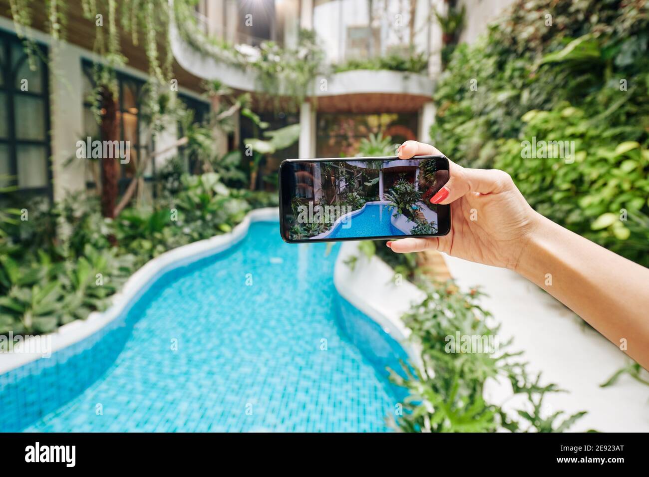 Woman photographing swimming pool Stock Photo - Alamy