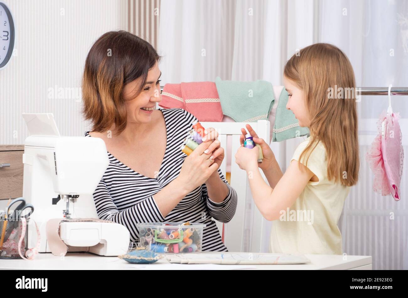Smiling sewing team choosing with which color thread to work Stock ...