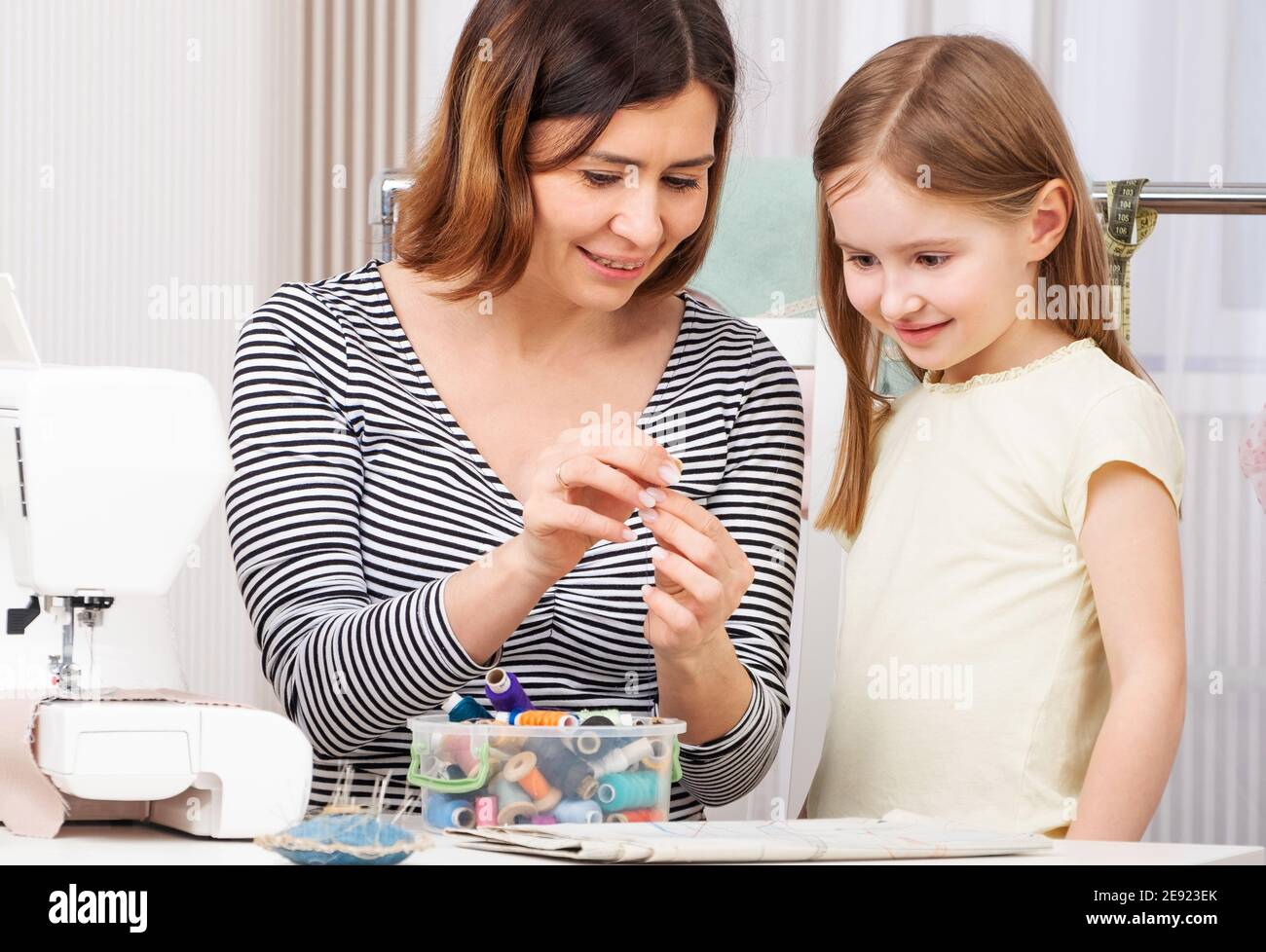 mother and daughter sew clothes in the workshop Stock Photo - Alamy