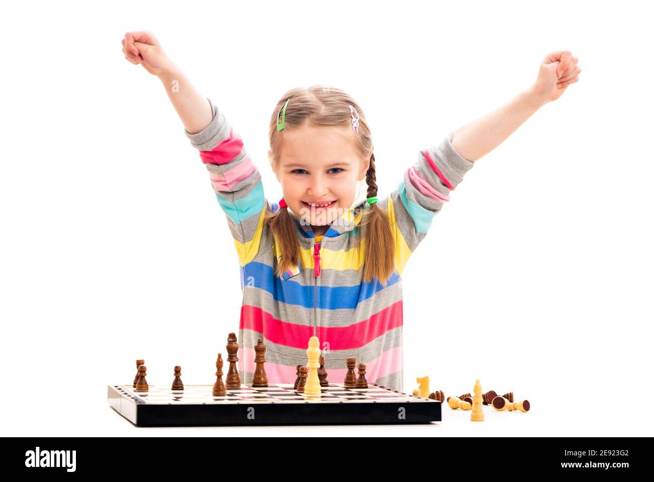 Adorable school age girl feels extremely happy about winning in chess ...