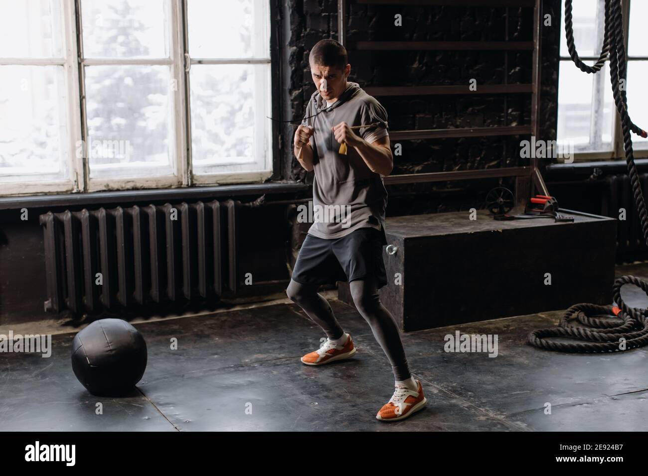 Cool man fighter in boxing bandages trains in the gym. Mixed martial ...